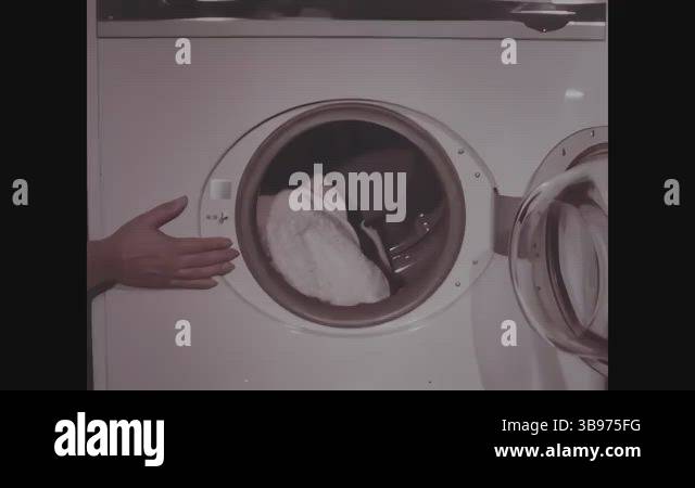 UNITED STATES - 1950s - A washer dryer spins a heavy shag rug. A man ...