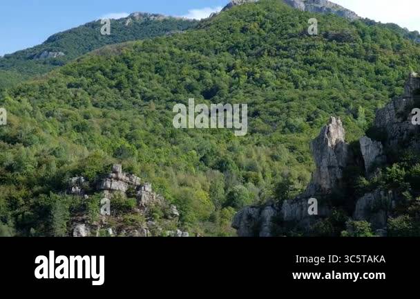 Green rolling fields with granite rock popping up overlooking forested ...