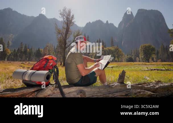 Devoted hiker studies a topographic map amidst the stunning scenery of ...