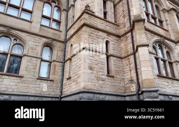 A closeup view of a historic stone building with ornate windows and ...