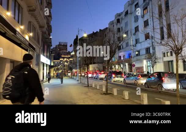 night city man passing by glowing lights buildings cars Bucharest Romania 03.09.2025 Stock Video ...