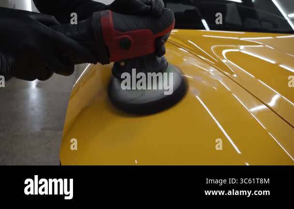 Detailing process of polishing yellow sports car hood surface using ...