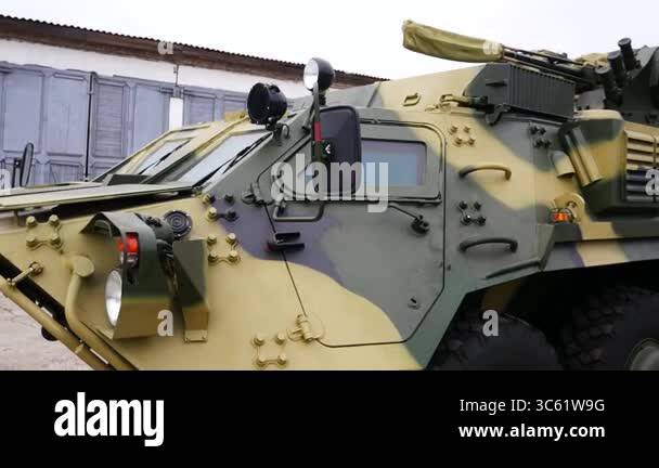 An armored personnel carrier against the background of a hangar with ...