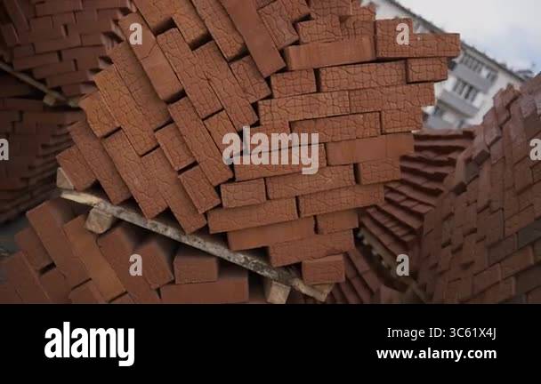 Stacks of red bricks arranged on wooden pallets at construction site ...