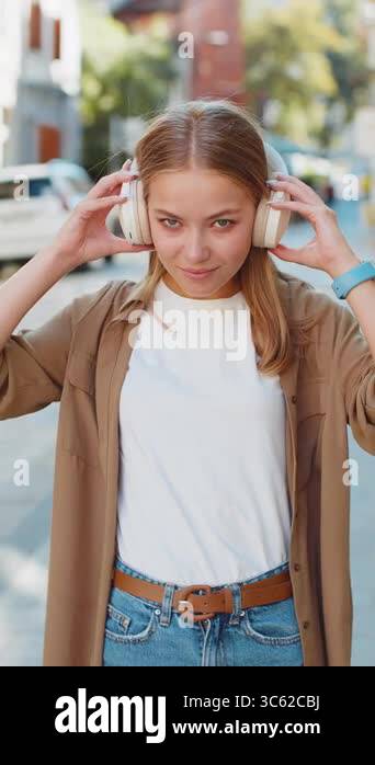 Portrait of happy smiling Caucasian young woman listening to music ...