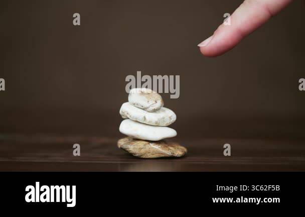 A hand points to stacks of balancing stones. Life coach, stability ...