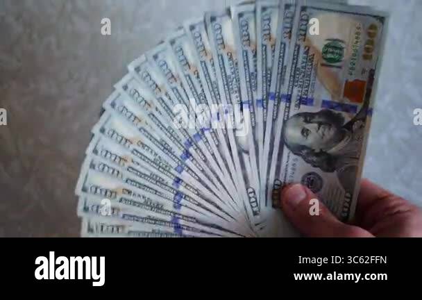 A stack of crisp, dollar bills, held in capable hands. Man counting ...