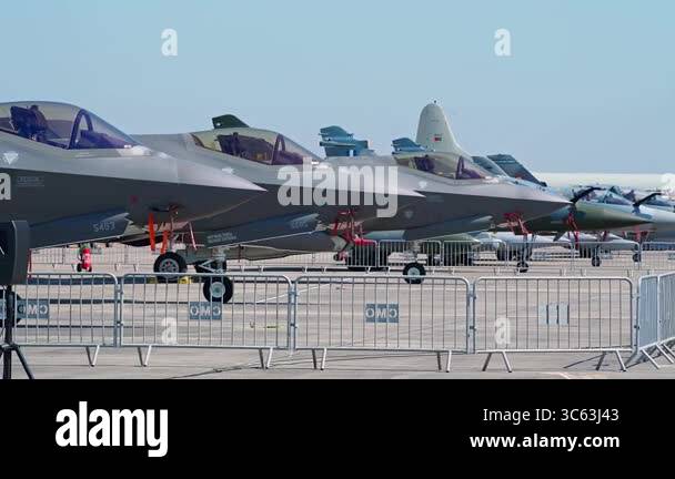 Several advanced fighter jets are parked in formation on an airfield ...