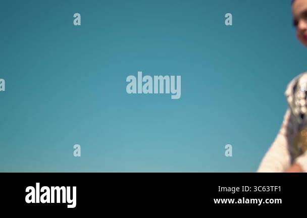 Two people holding a woven basket with a wooden base against a clear ...