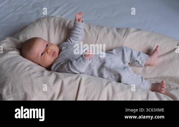 Active newborn baby lying in a cradle in the living room at home ...