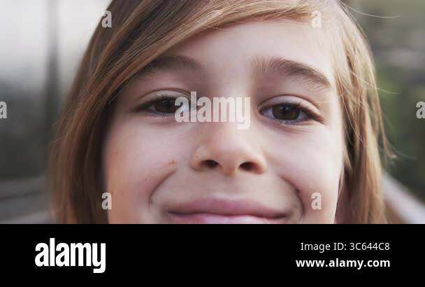 Smiling child with long hair looking at camera, close-up portrait ...