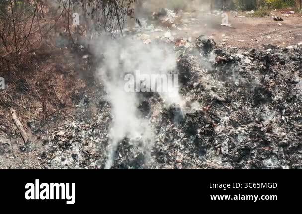 Garbage, fire burning and smoke in landfill. Also called trash, waste ...