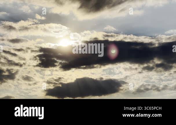 Sunlight breaking through cumulus cloud at sunset. Sun going down ...
