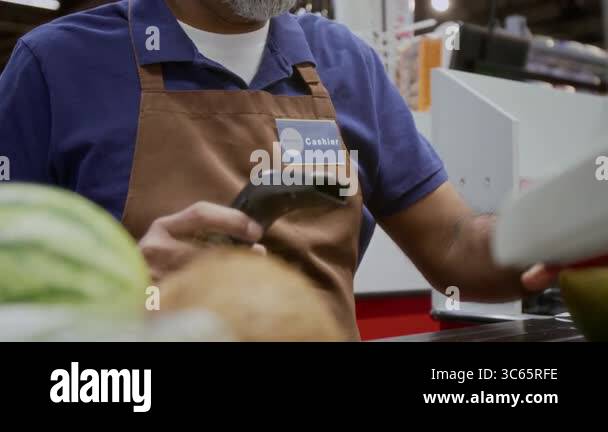 Cropped shot of unrecognizable male cashier scanning items while ...