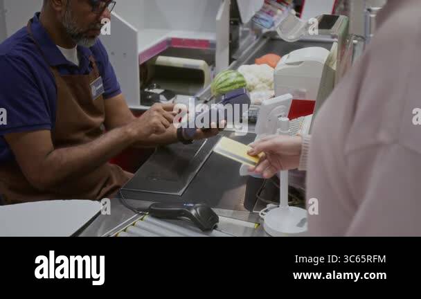 Cropped shot of male cashier giving banking terminal to woman paying ...