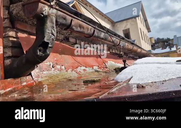 Rusty gutters on the roof of an industrial building. Water seeping into ...