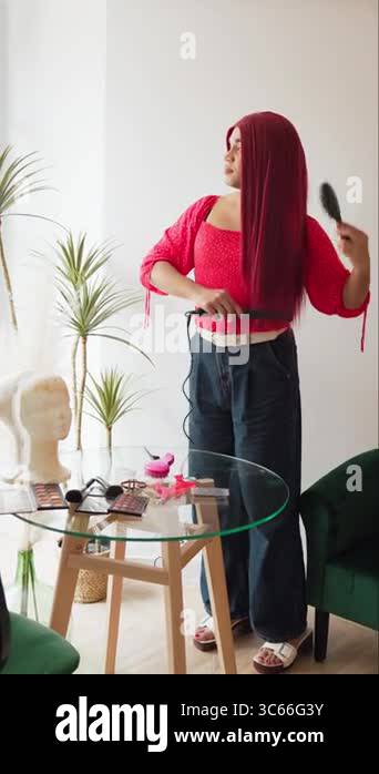Transgender woman styling red wig at home Stock Video Footage - Alamy