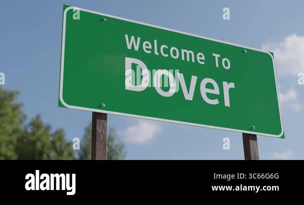 Driving By A Welcome To Dover, Delaware Green Road Sign Against a Blue ...