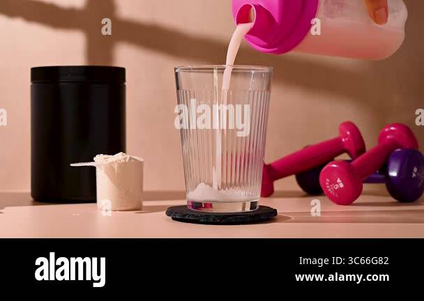 Pouring strawberry protein shake in a glass. Food supplement, fitness ...