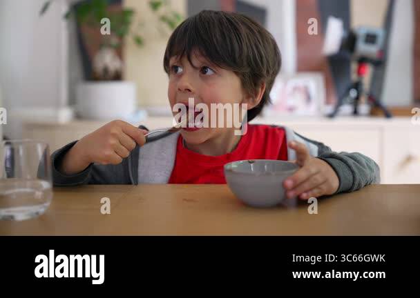 Young boy enjoying a homemade chocolate dessert, savoring each spoonful ...
