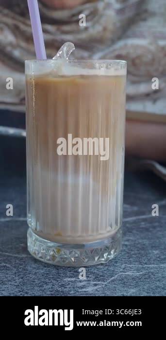 Enjoy a layered iced coffee drink served in a tall glass on a warm day ...