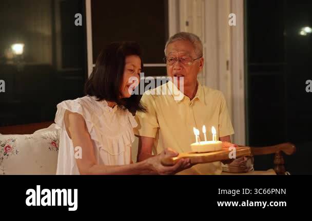 Senior asian couple is happily celebrating birthday together at home ...