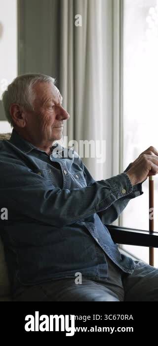 Silent retired senior man sitting alone in armchair or sofa holding ...