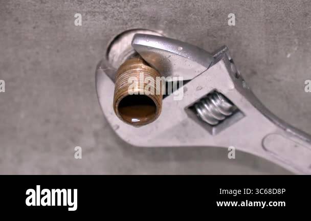 Professional plumber tightening brass pipe fitting with adjustable ...