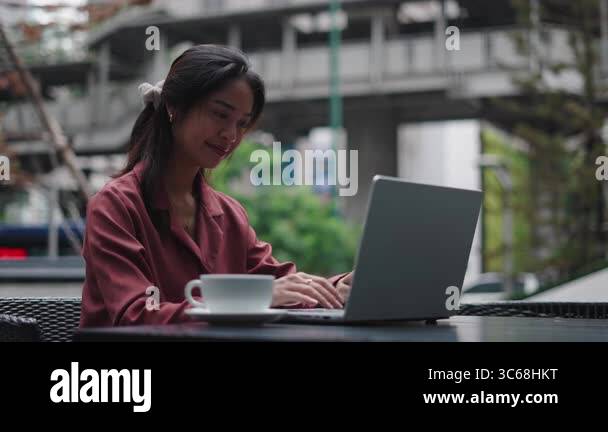 Young Asian freelancer working with laptop in outdoor cafe - 4K ...