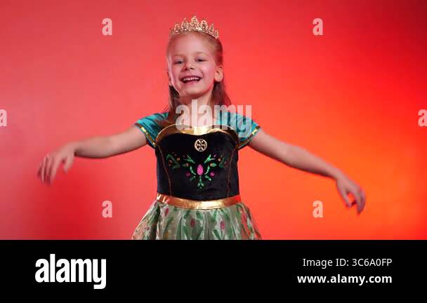 A little princess poses for the camera, laughs and dances funny ...