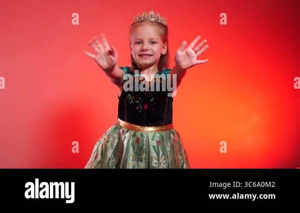 A radiant princess, arms outstretched, waving hello. Joyful child in a ...