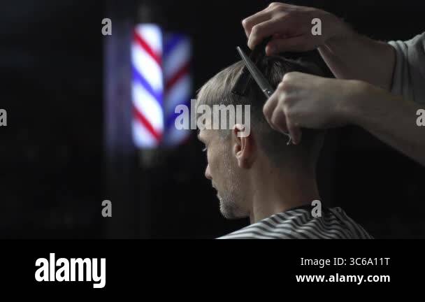 Professional barber grooming male clients hair with scissors, vintage ...