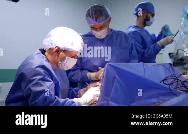 Experienced male surgeons perform brain surgery. Medic at backdrop ...