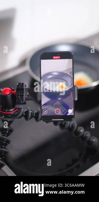 A cooking tutorial demonstrates frying an egg in a pan while a ...