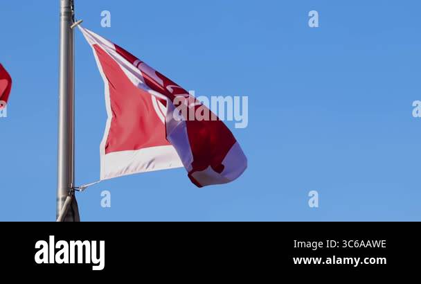 A red and white flag of Calgary with the city's stylized "C" logo ...