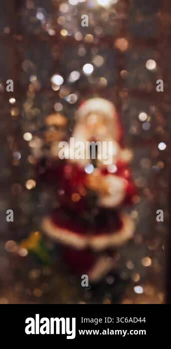 Close up of a blurred Santa Clause figurine in a snow globe with ...