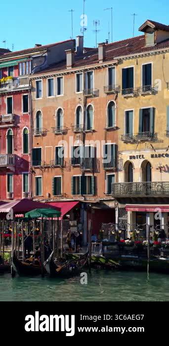 Multiple boats docked on the side of a canal on a sunny day. Vertical ...