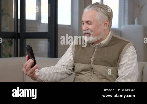Happy good looking senior grey haired bearded man on retirement making ...