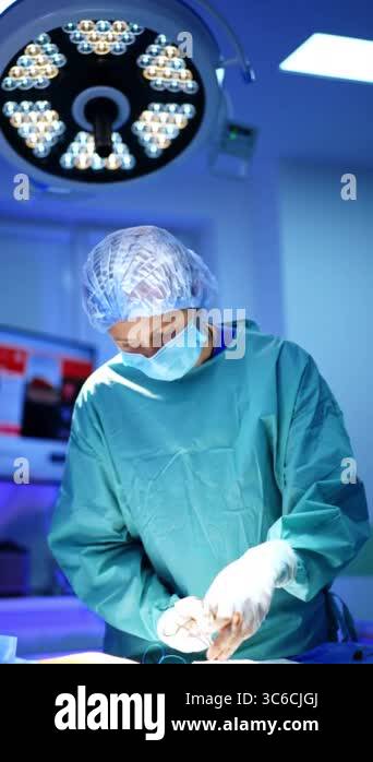 Female doctor uses metal tools and thread to sow the incision. Surgeon ...