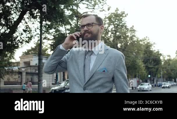 A stylish and confident businessman is talking on his mobile phone ...