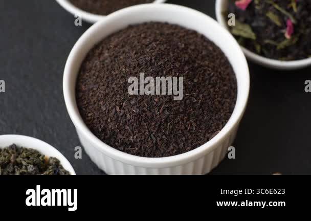 Black tea dry crushed in bowl on dark concrete background Stock Video ...