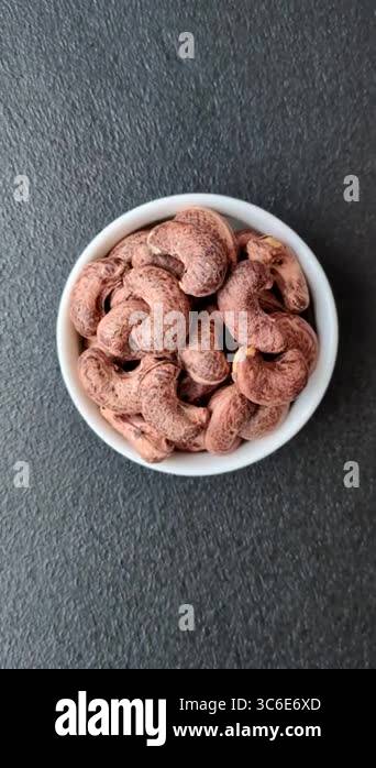 Cashew nuts in shell in bowl on dark concrete background Stock Video ...