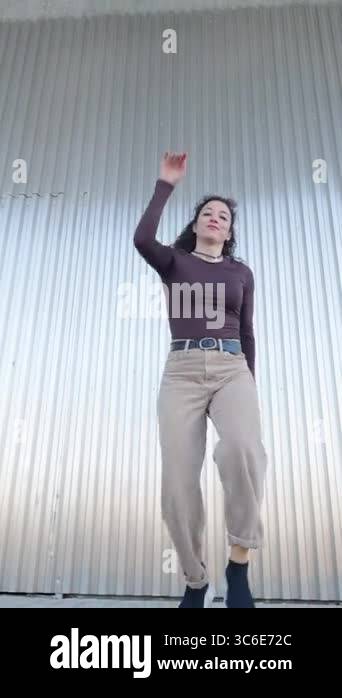 Passionate female dancer performing dynamic urban dance moves with ...