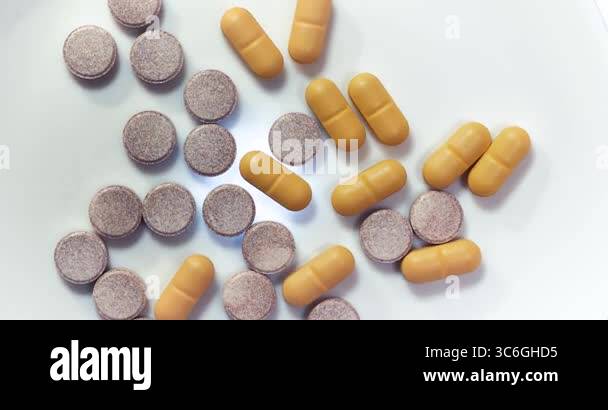 Medicine or drug pills spinning on a glowing transparent surface with ...