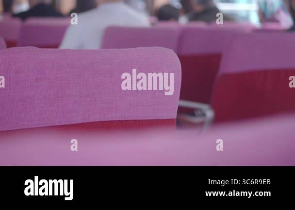 People gather in a vibrant waiting area with pink chairs Stock Video ...