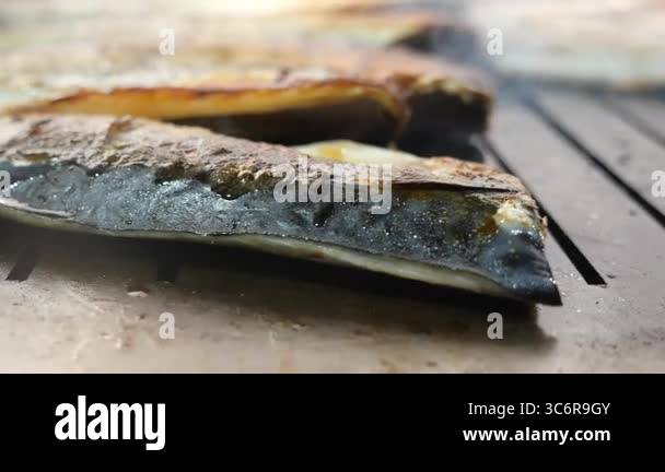 Juicy fish grilling over hot coals, filling the air with delicious ...