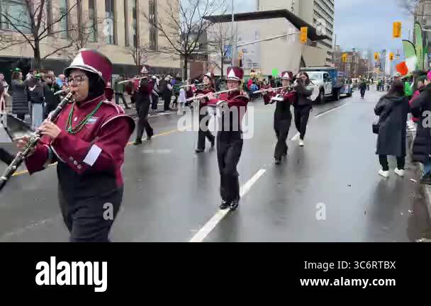 A colorful marching band with flutes performs at a lively city event ...