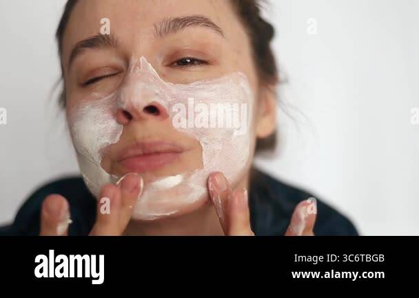 Young woman applying white peeling mask. Facial skin care Stock Video ...