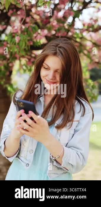 Vertical Format Video of a beautiful woman using a smartphone in the ...