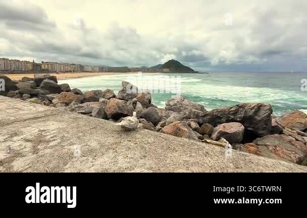 Experience a tranquil beach scene that features rugged rocky shores and ...
